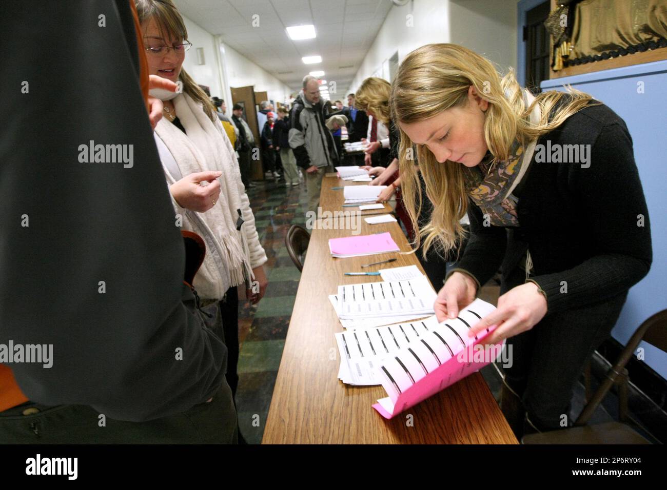 Briana Tully helps caucus-goers Tuesday, Jan. 3, 2012, during the ...