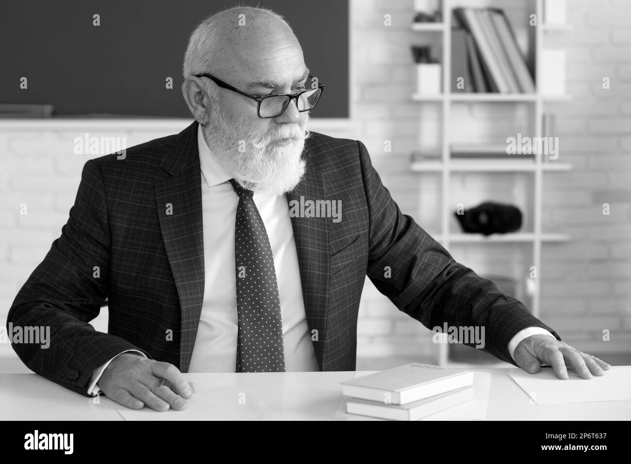 Elderly man teacher on a blank chalkboard during lesson, teaching class ...