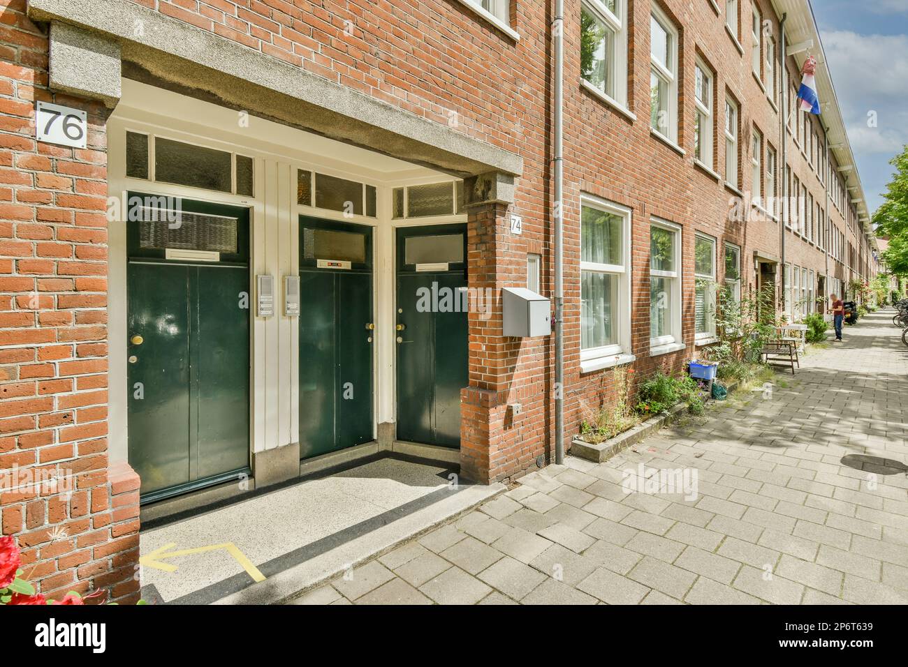 a brick building with two green doors on each side and one door open to ...