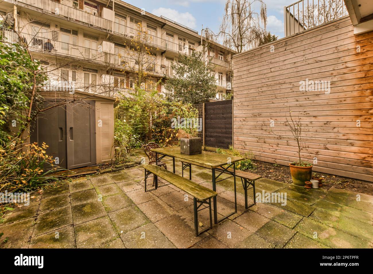 an outdoor area with tables and benches in the middle of the yard, next ...