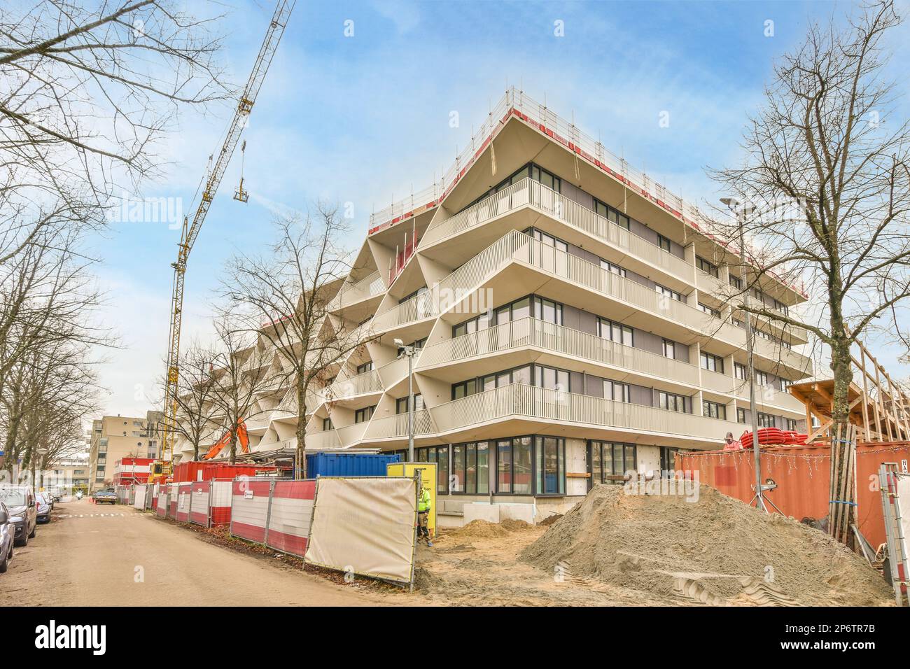 a building being built on the side of a road in front of a construction ...