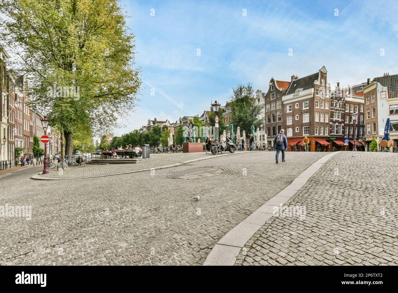a city street with people walking and sitting on benches in the middle ...
