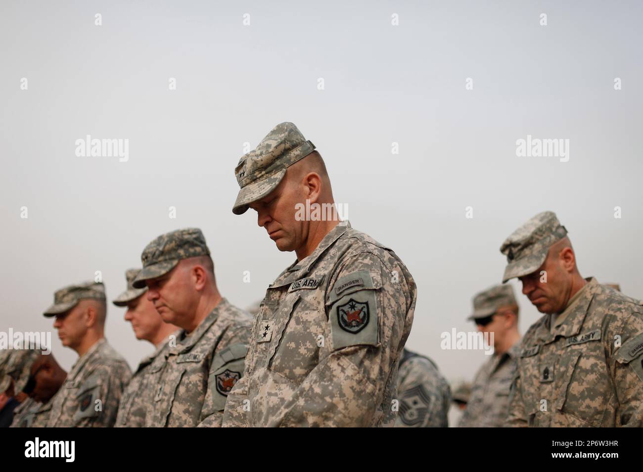 Military personnel lower their heads during ceremonies of the encasing ...