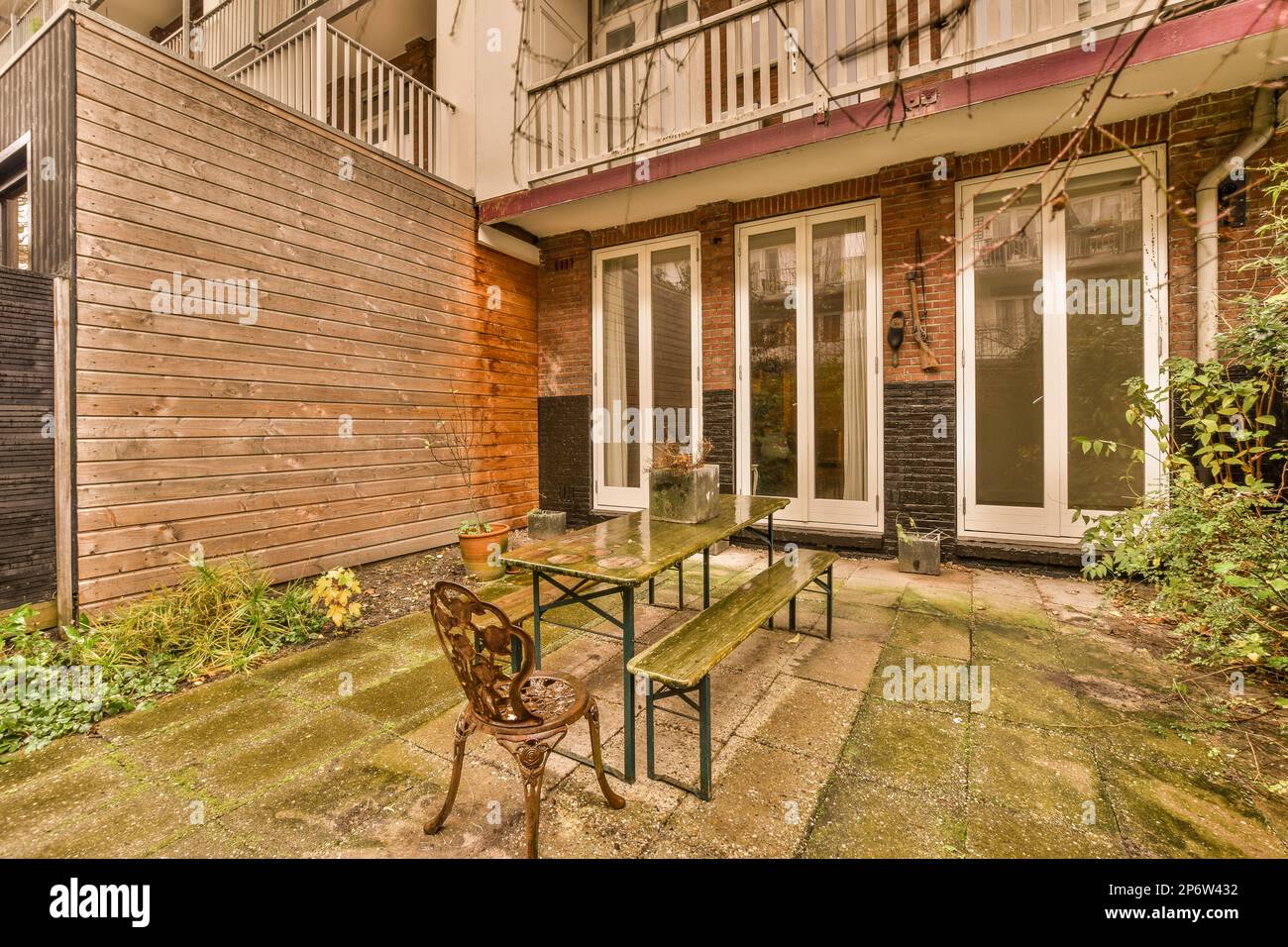 an outside area with a bench and table in the middle of the yard, next ...