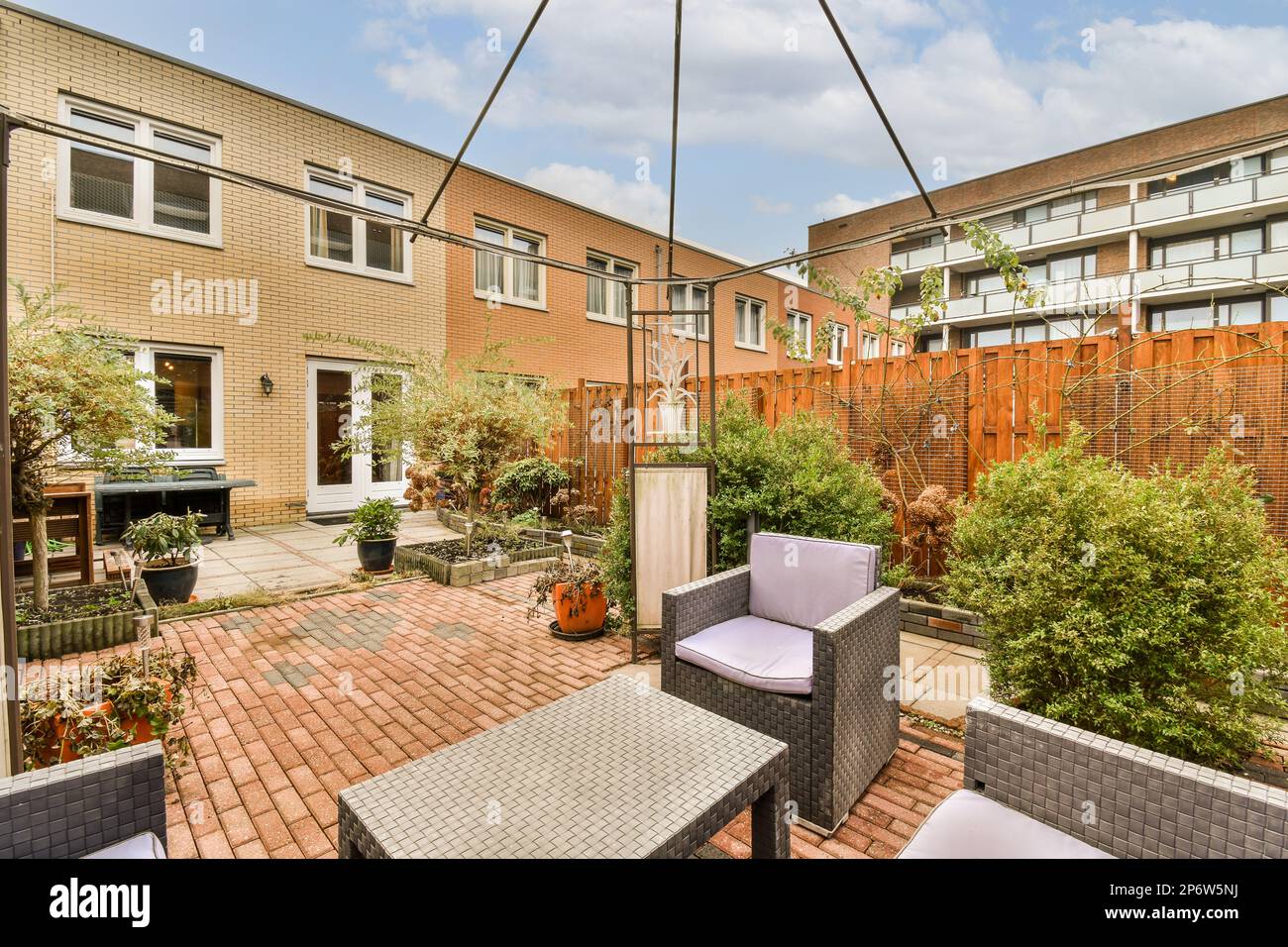 a patio with chairs, tables and an umbrella over the back yard area in ...