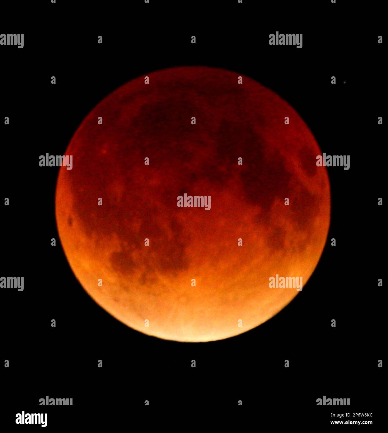 The moon takes a reddish glow during the lunar eclipse in Tokyo on Saturday night on Dec. 10 ...