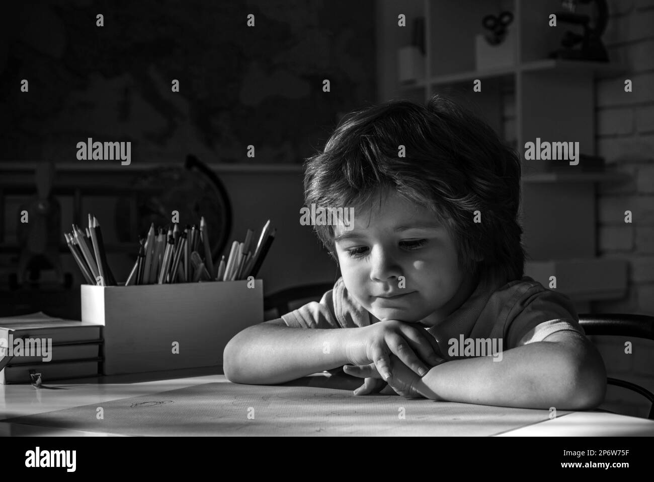 Cute pupil with funny face schooling work. Cute child boy in classroom ...
