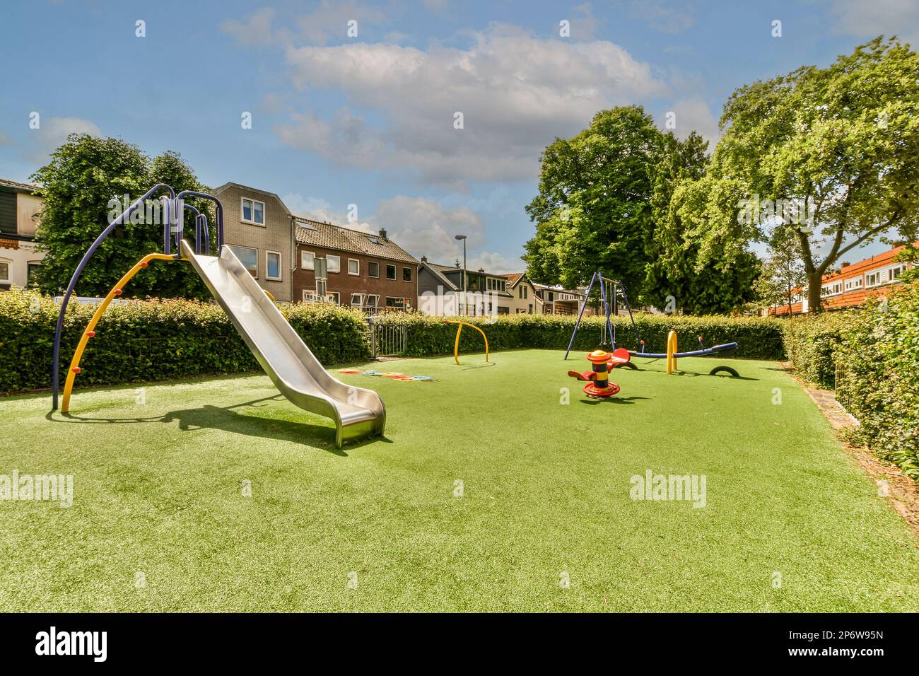 an outdoor play area with a slide set up in the middle and two children ...