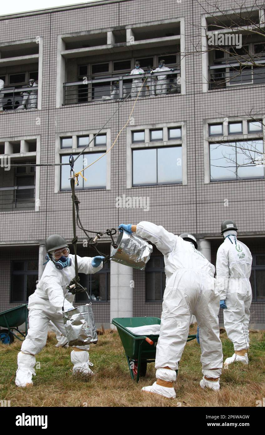 Members of Japan Ground Self-Defense Force (JGSDF) remove soil and ...