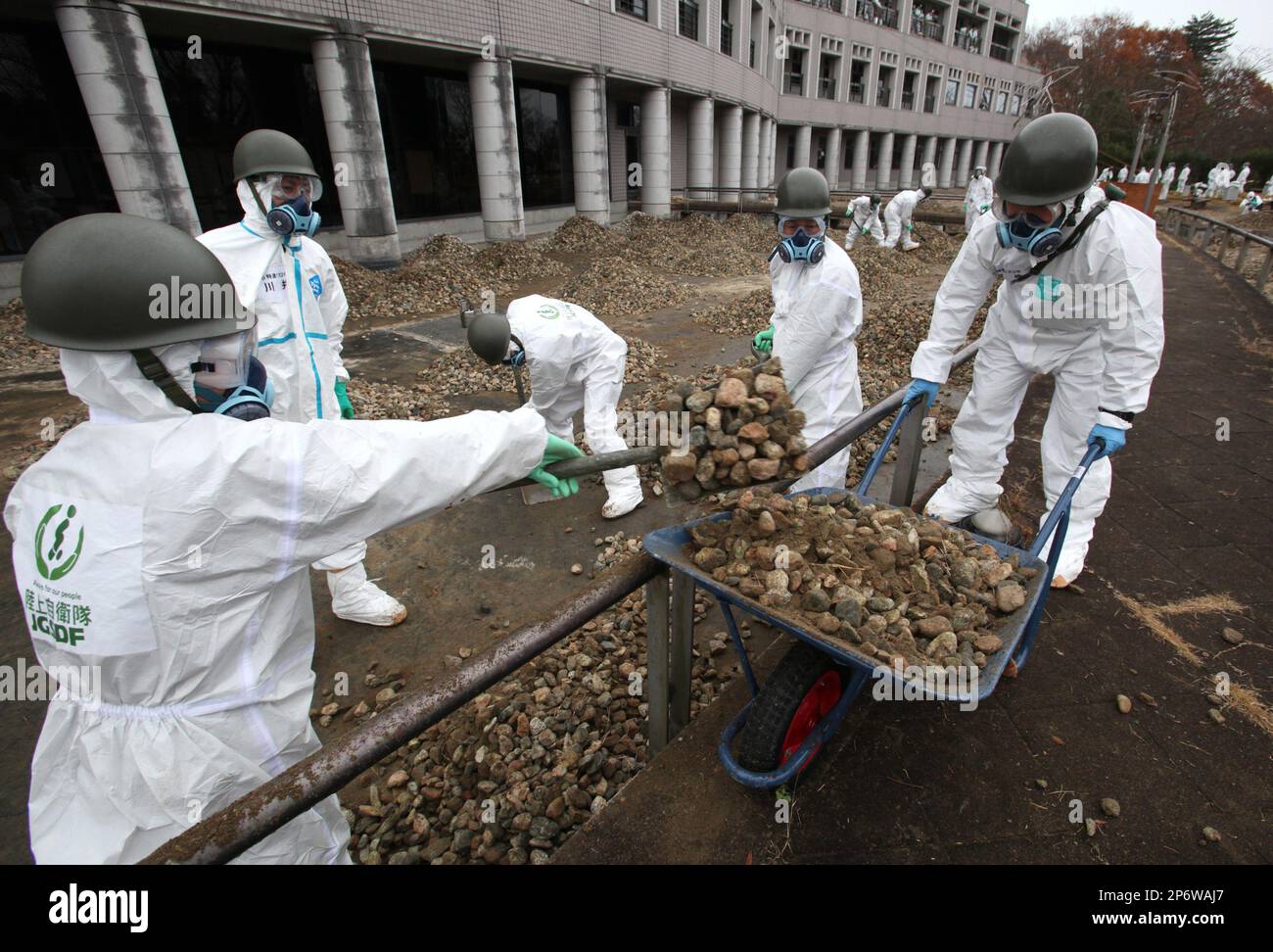 Members of Japan Ground Self-Defense Force (JGSDF) remove soil and ...