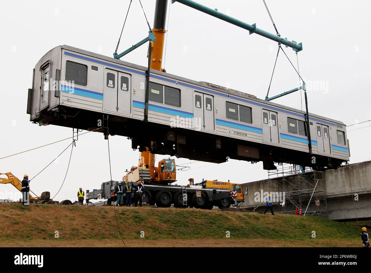 East Japan Railway Co. starts to lift up a stranded train car by a ...