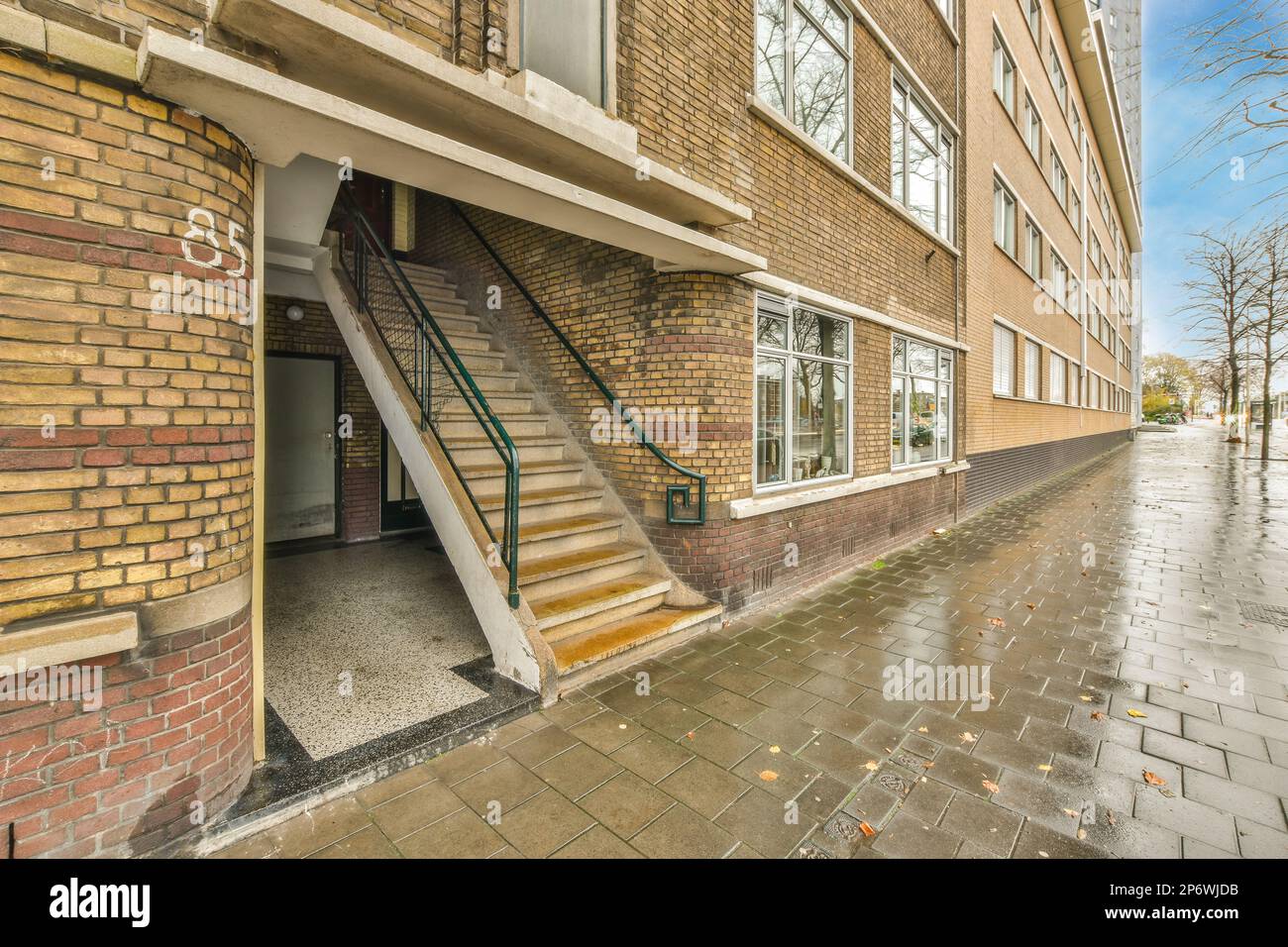 a brick building with stairs leading up to the front door and an open ...