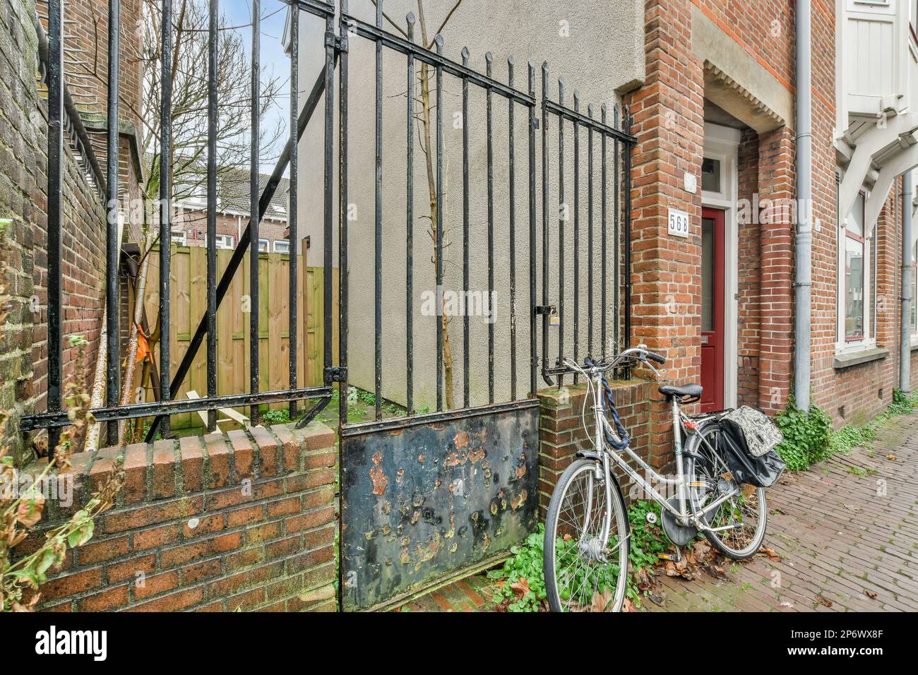 a bike leaning against a brick wall in front of a house with an iron ...