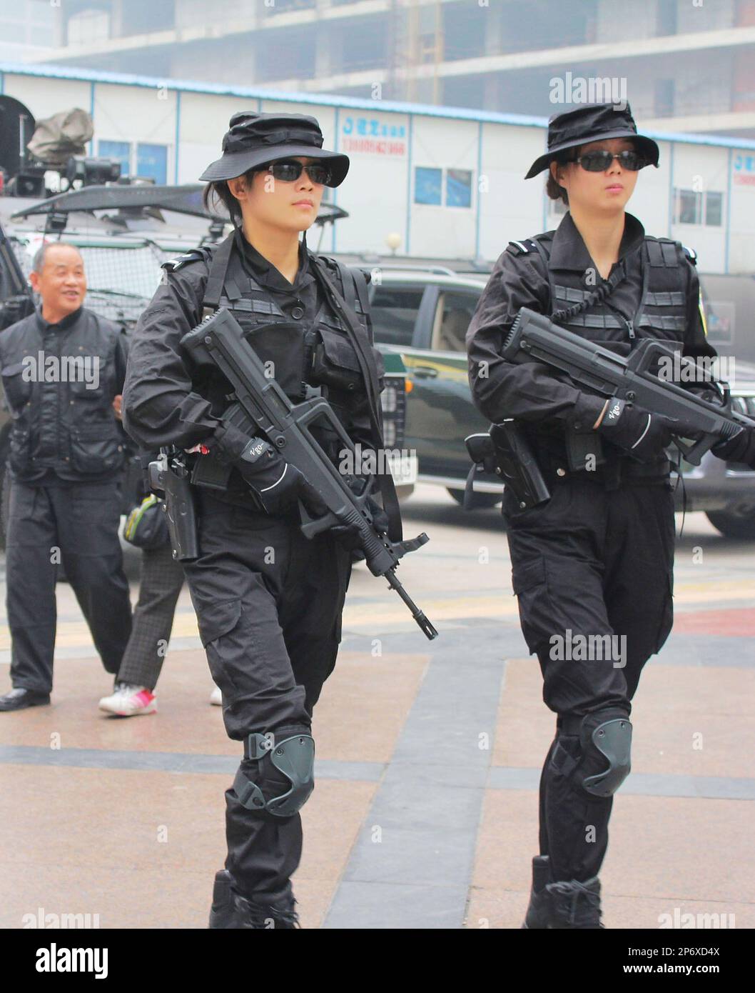Three female SWAT members and two male armed with M4 guns patrol on a ...