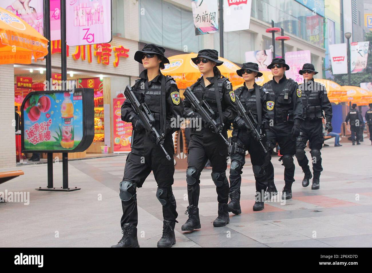Three female SWAT members and two male armed with M4 guns patrol on a ...