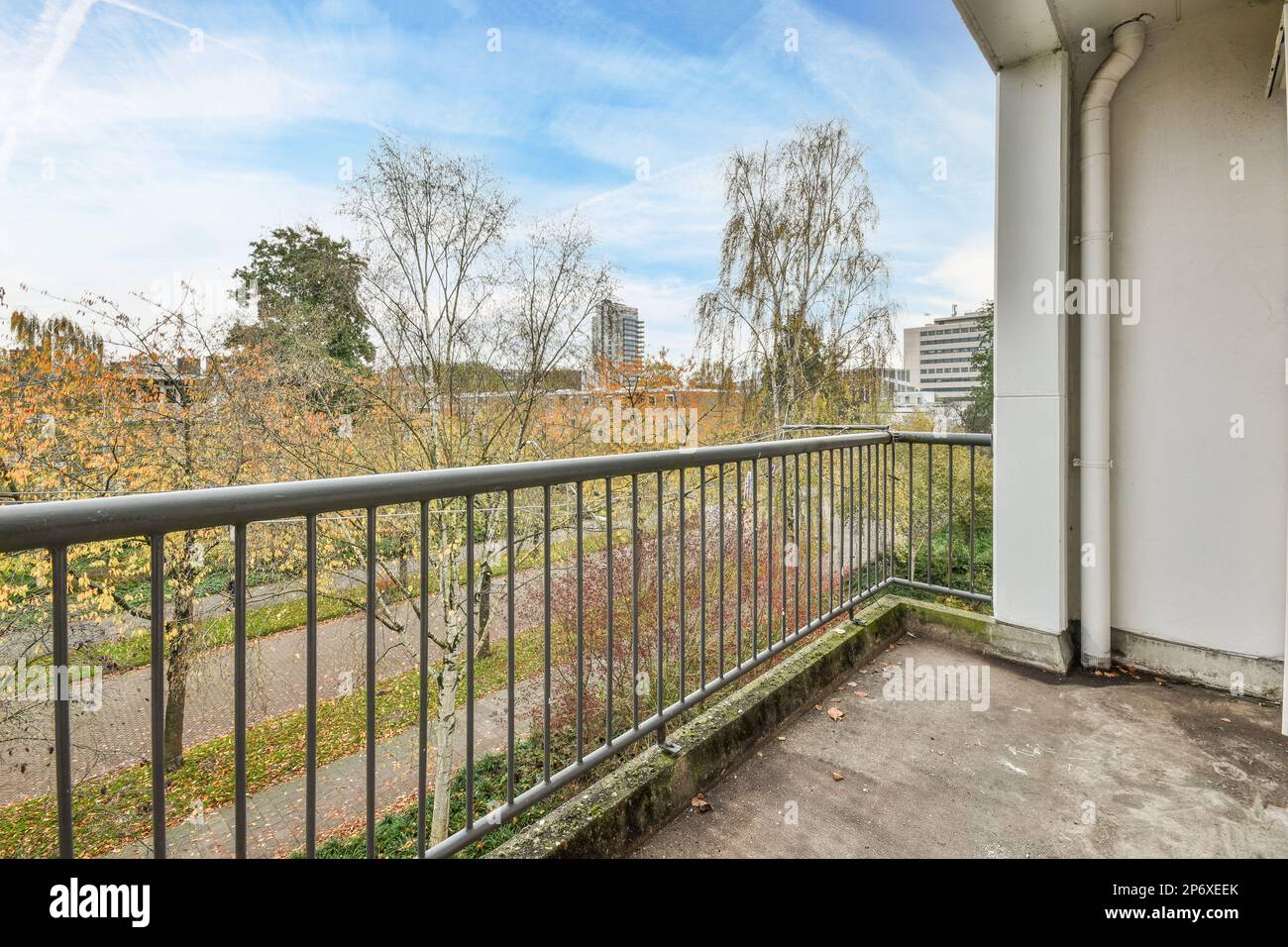 a balcony with trees in the background and blue sky above it, taken ...