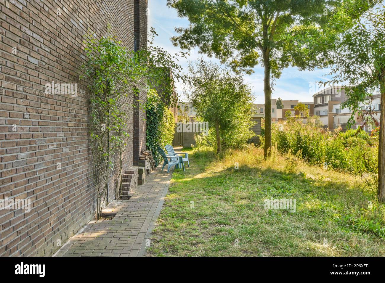 an empty backyard with brick walls and green grass in the yard is ...