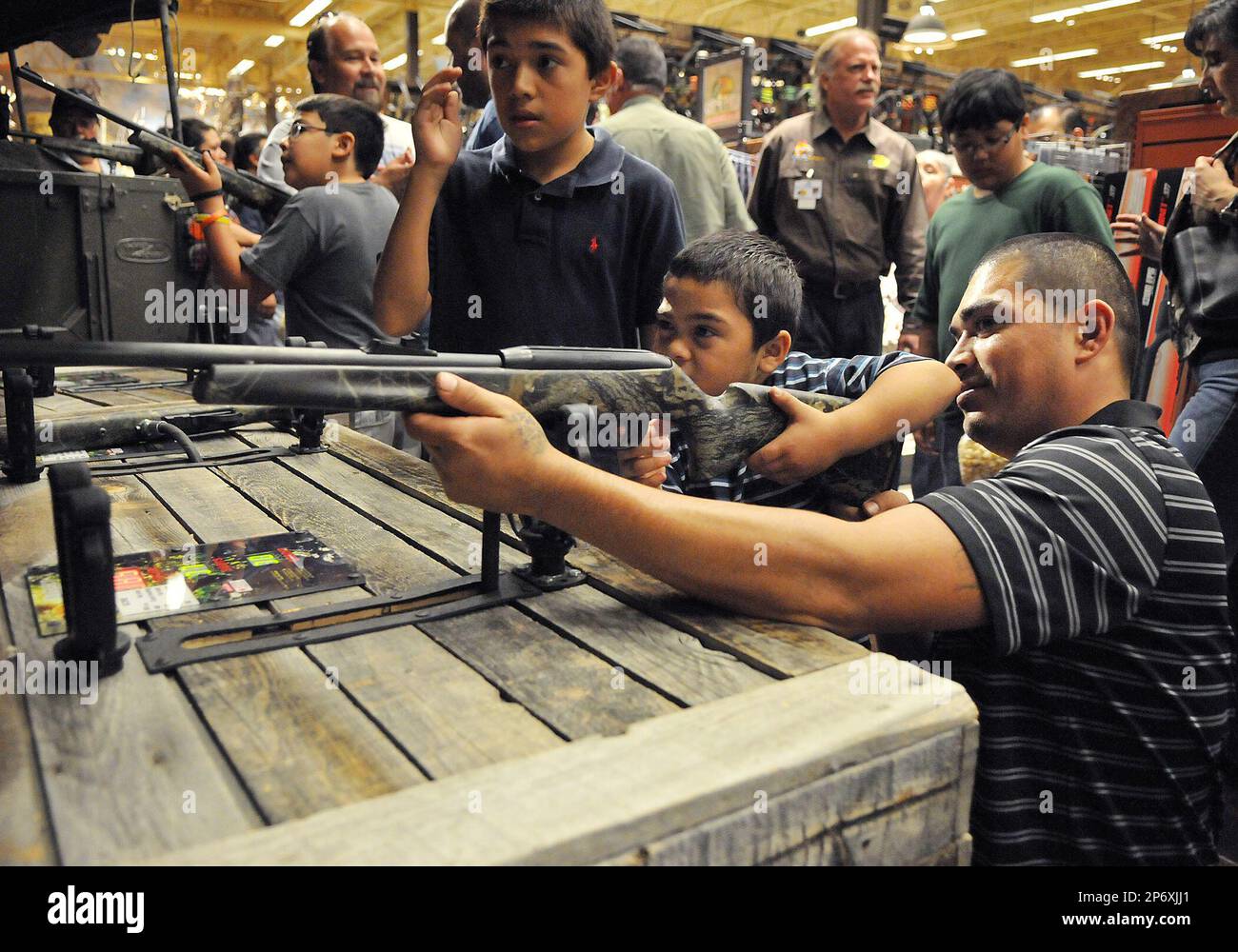 Rick Acosta, and his four year old son Ramleo, play a target shooting ...