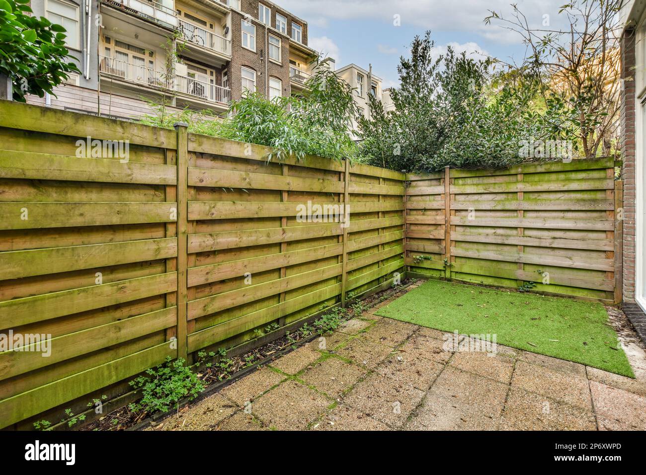 an empty backyard with wooden fences and green grass in the yard is ...