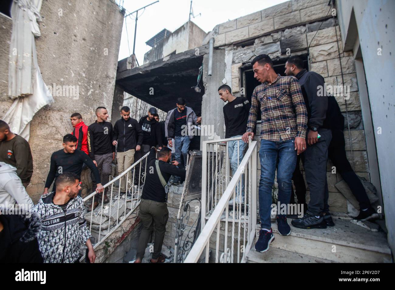 Palestinians inspect a destroyed house, bombed by the Israeli army, in ...