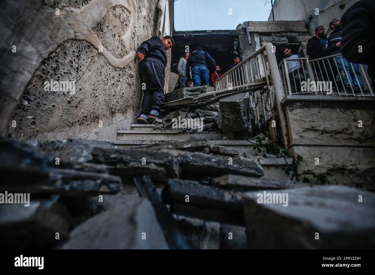 Palestinians inspect a destroyed house, bombed by the Israeli army, in ...