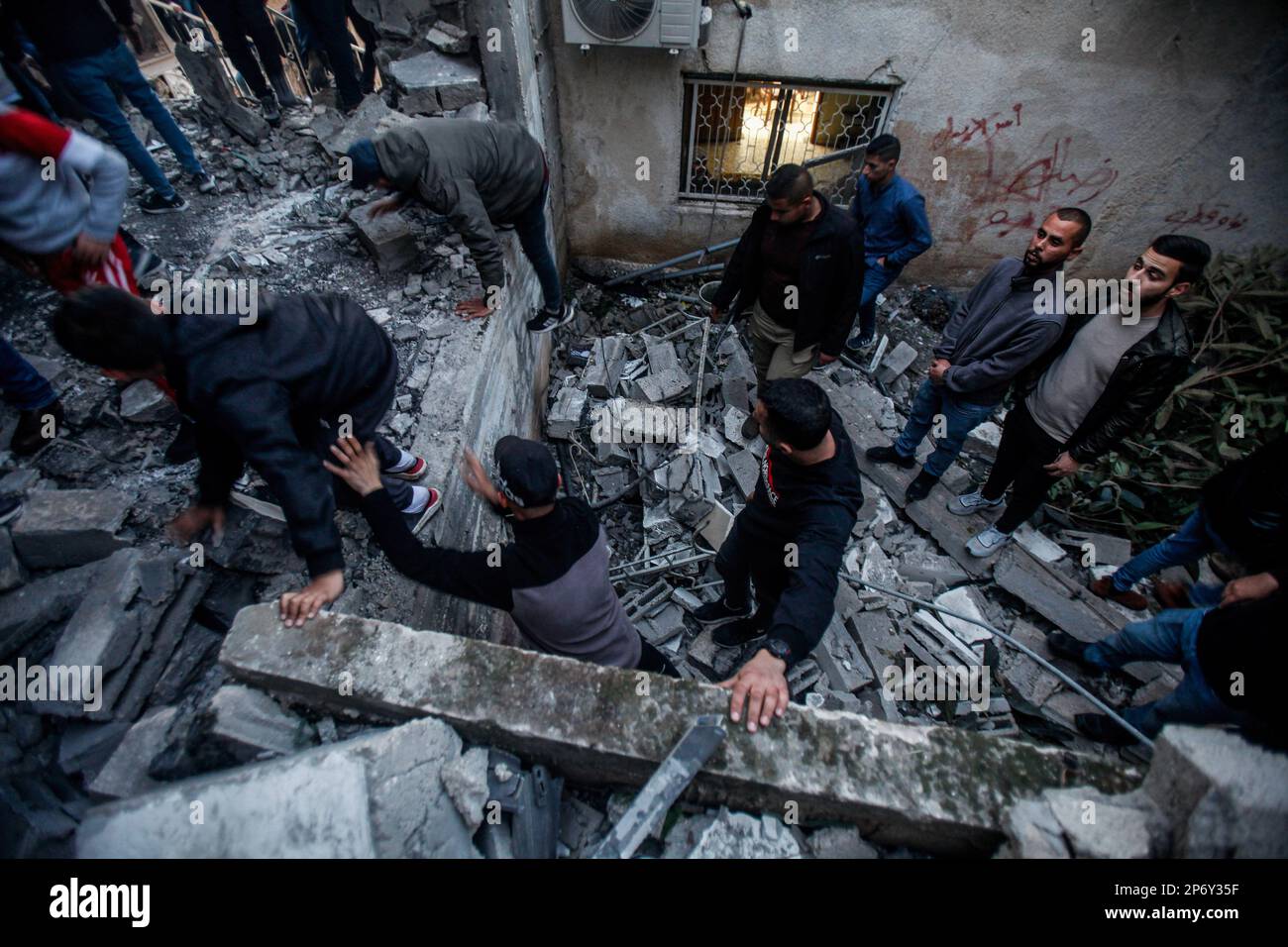 Palestinians inspect a destroyed house, bombed by the Israeli army, in ...
