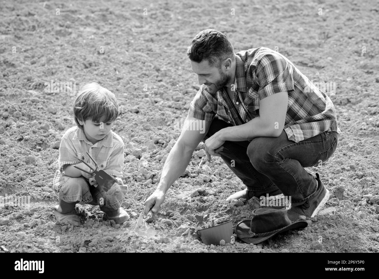 Father teaching his son gardening. Farmer family harvesting vegetables ...