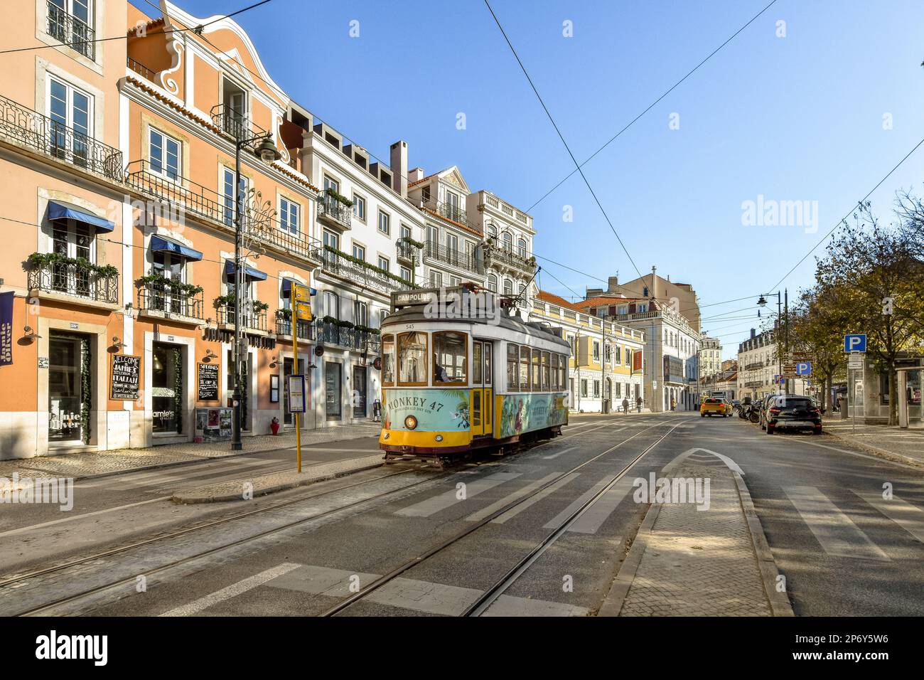 a street scene with a trolley car on the road and buildings in the ...