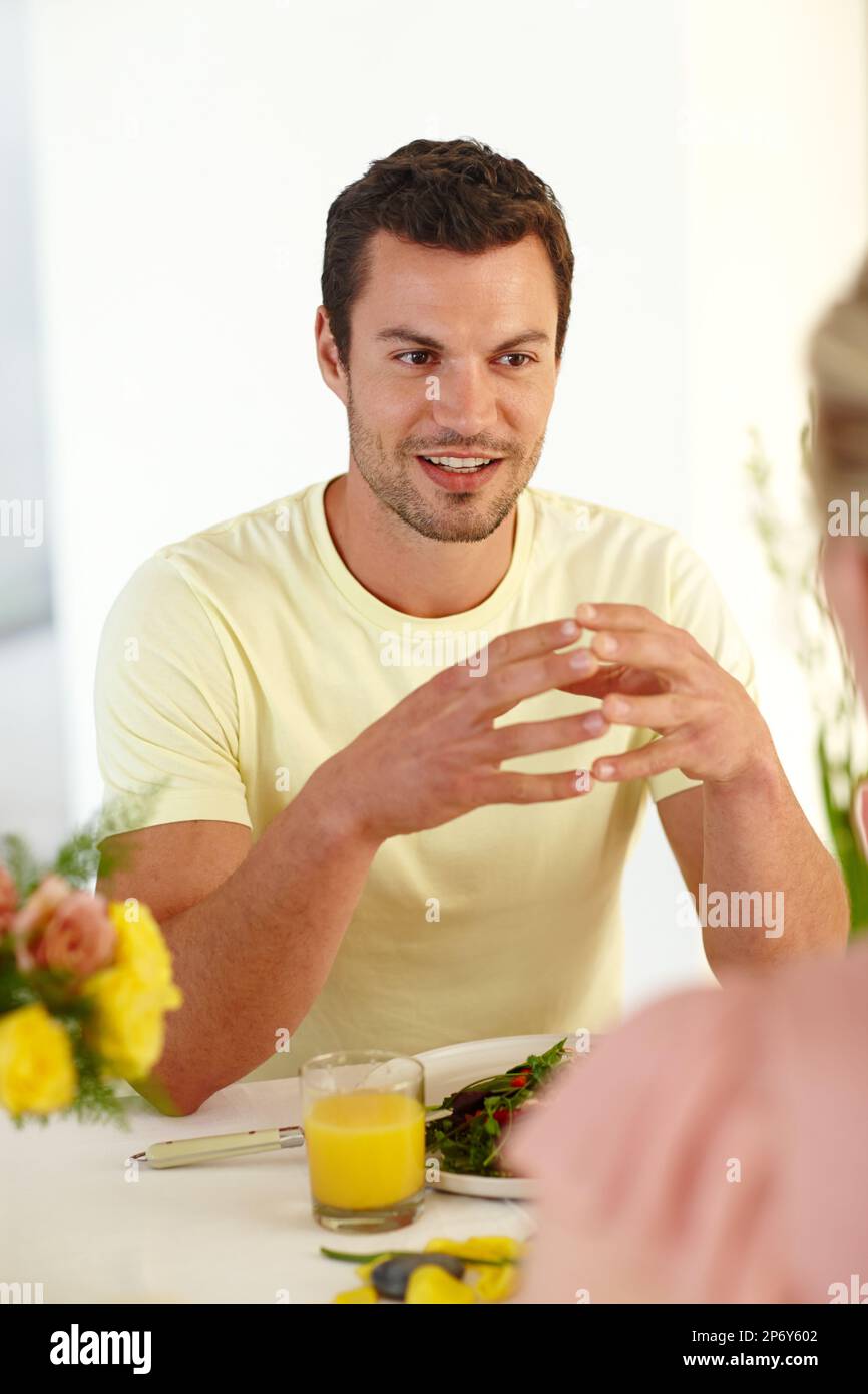Conversations across the dining table. A handsome man enjoying a ...