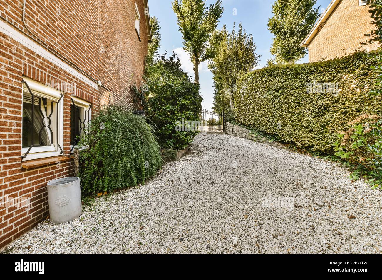 an alley with trees and bushes on either side of the street that leads ...