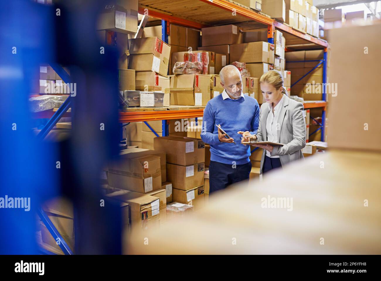 We always double check orders. a man and woman inspecting inventory in a large distribution ...