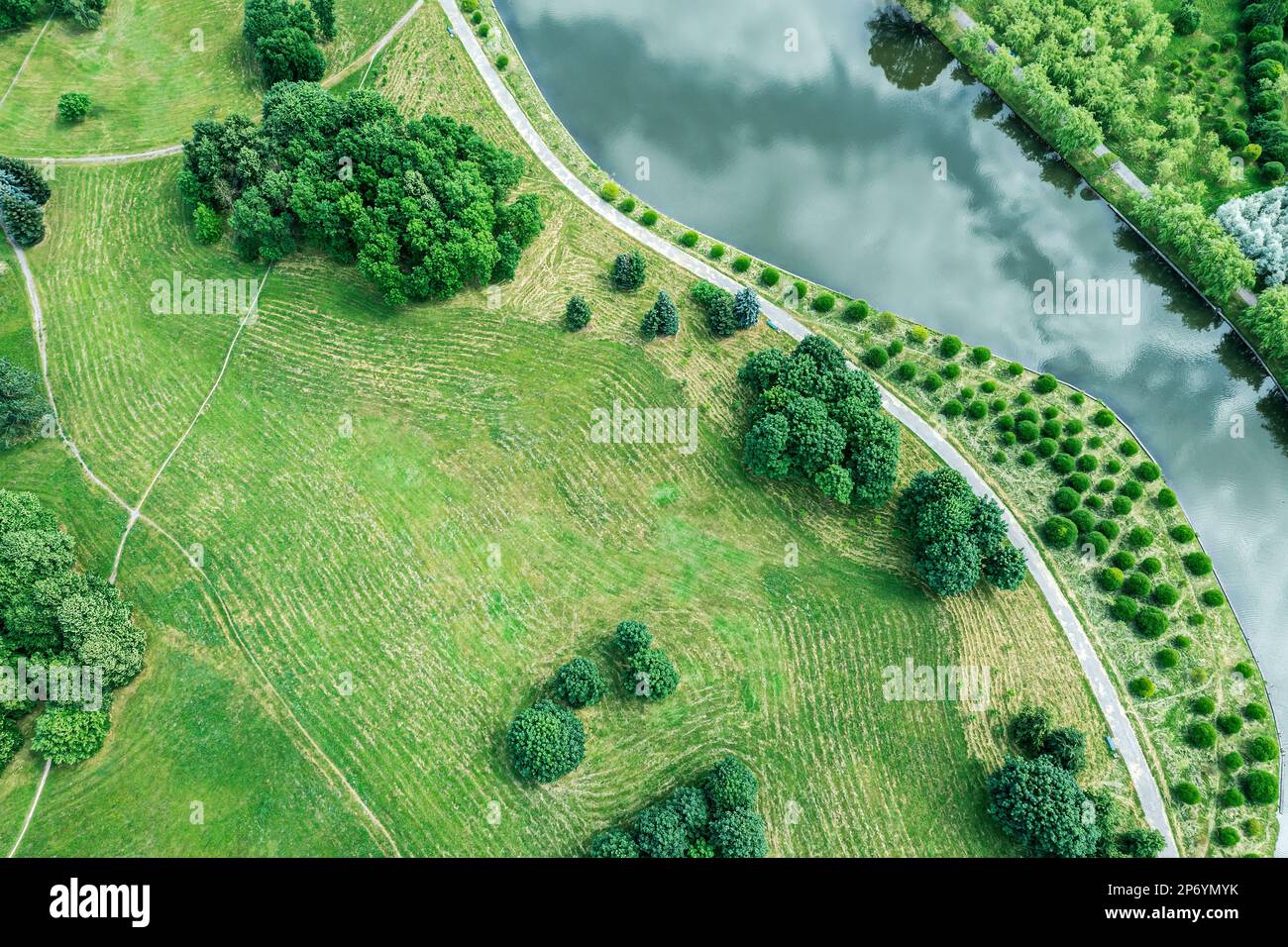 walking path on riverbank in summer park. river with cloudy sky ...
