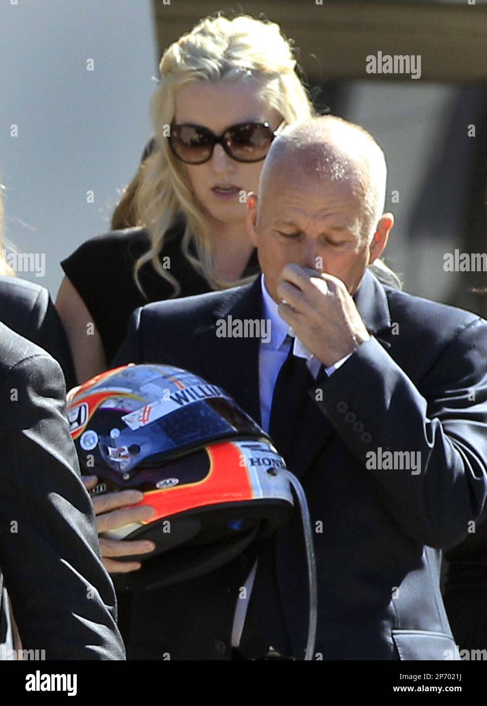 Clive Wheldon, right, father of IndyCar driver Dan Wheldon, wipes his ...