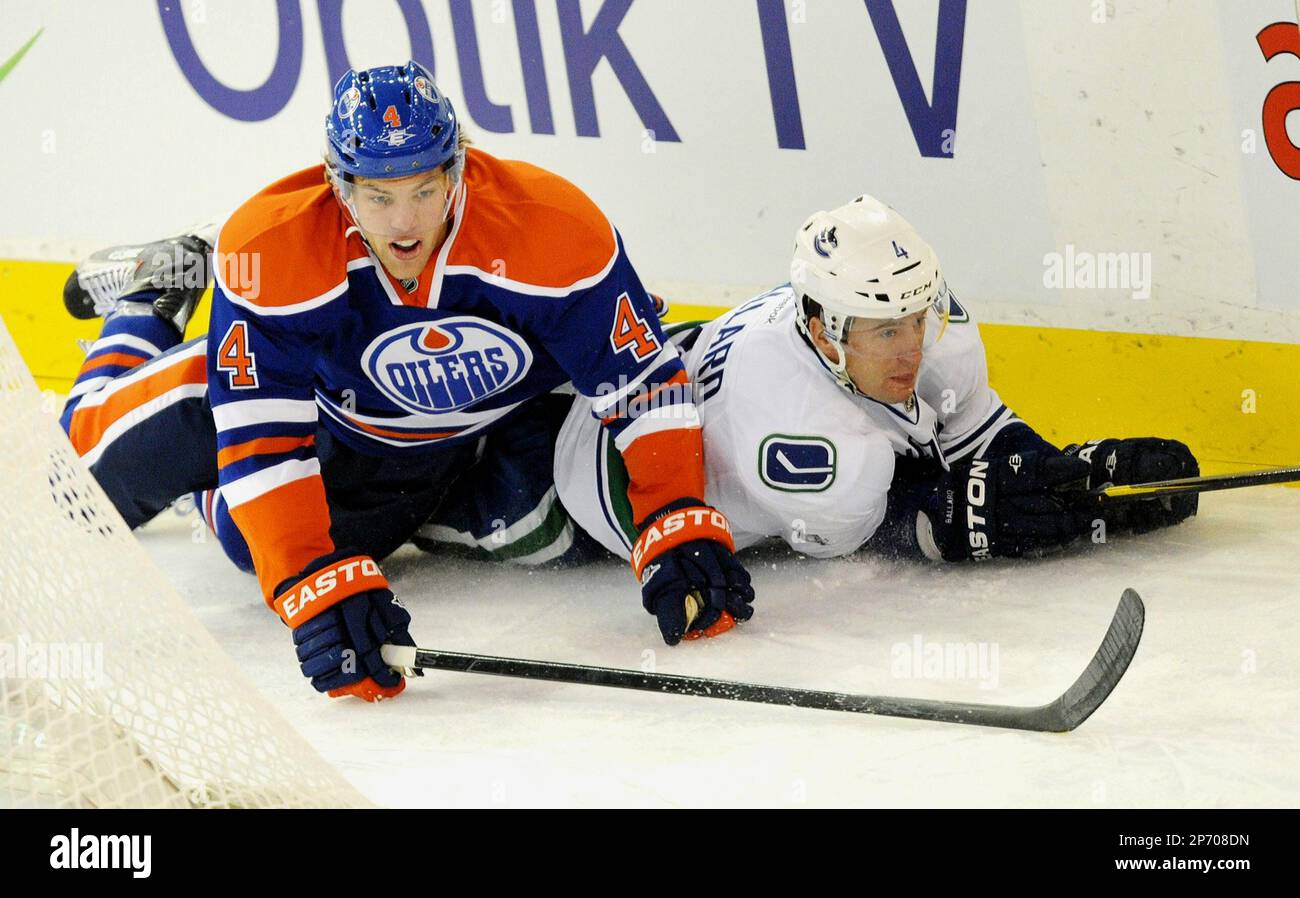 Edmonton Oilers' Taylor Hall, left, falls on the Vancouver Canucks ...