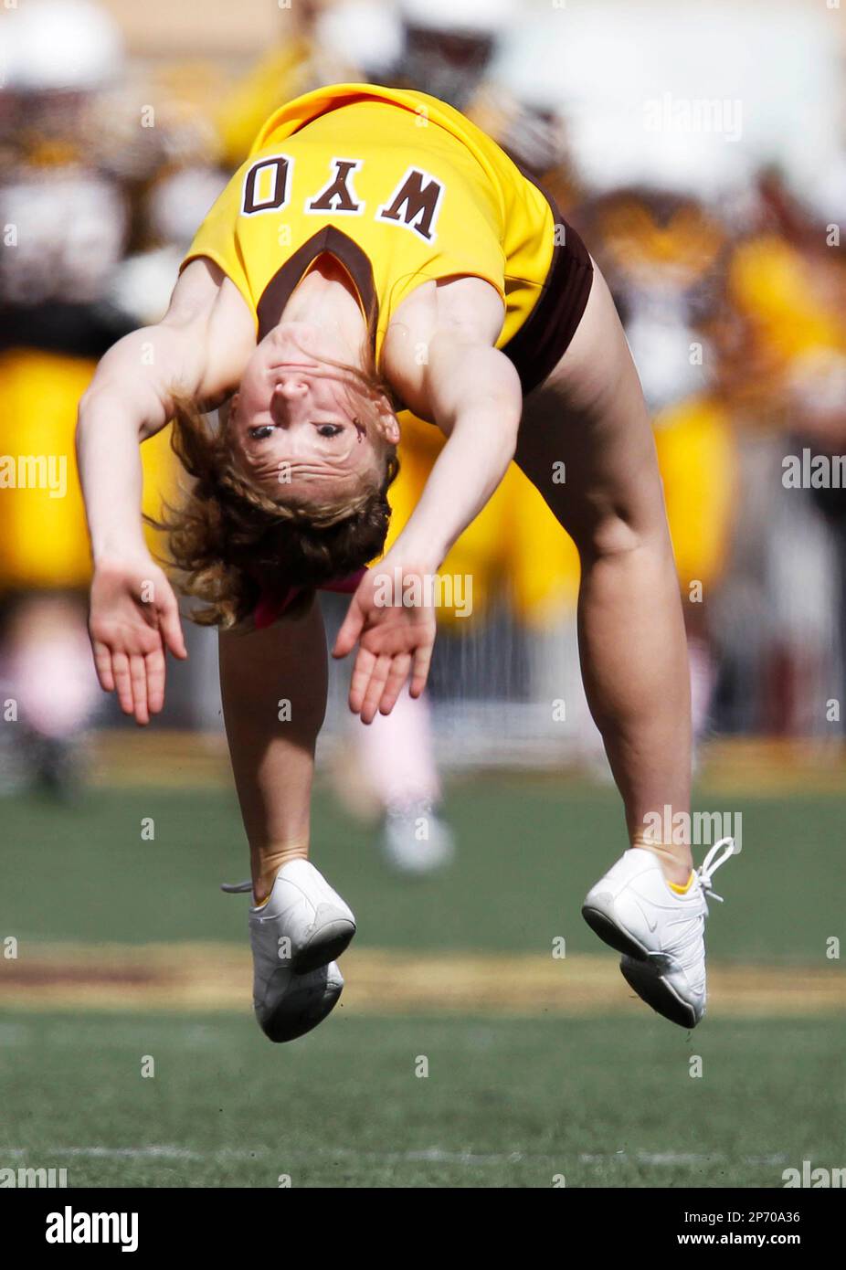 A Wyoming cheerleader does a back flip during an NCAA college football ...