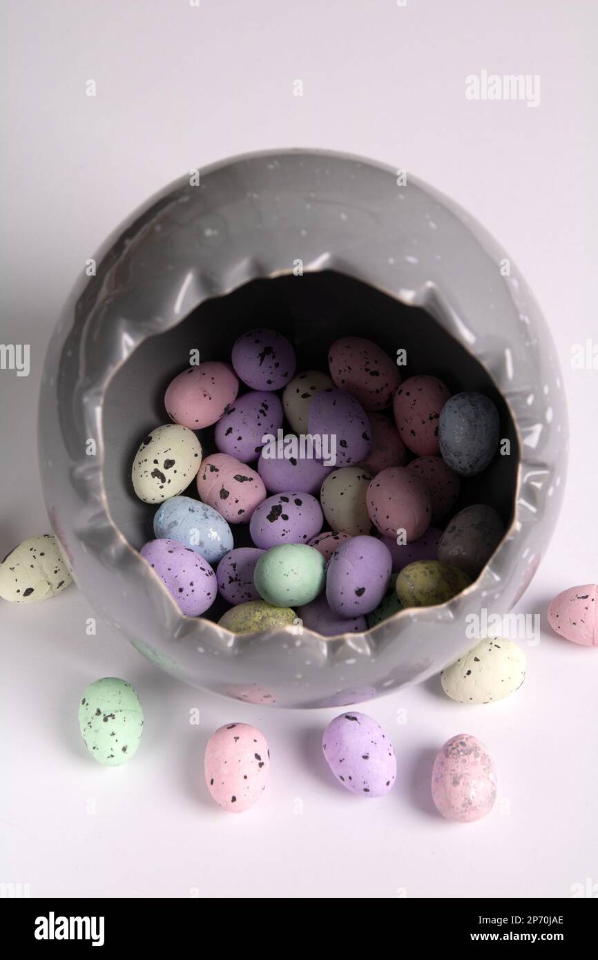 photo in a large gray egg there are small multicolored eggs on a white ...