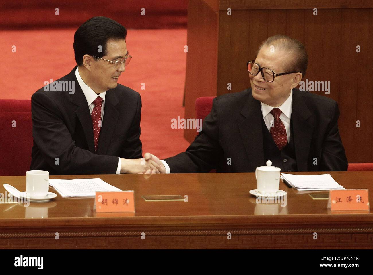 Chinese President Hu Jintao (L) shakes hands with former leader Jiang ...