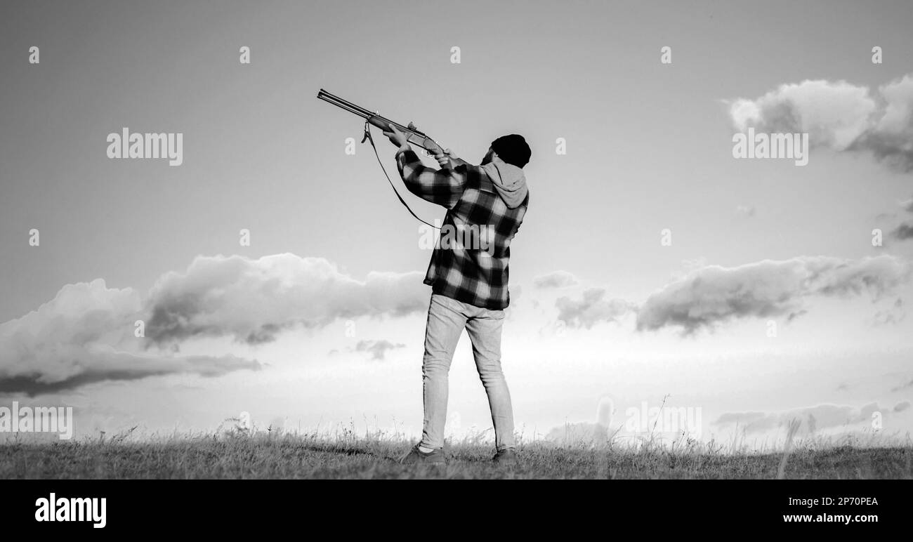 Skeet shooting. Hunter aiming rifle in forest. Hunter with shotgun gun ...