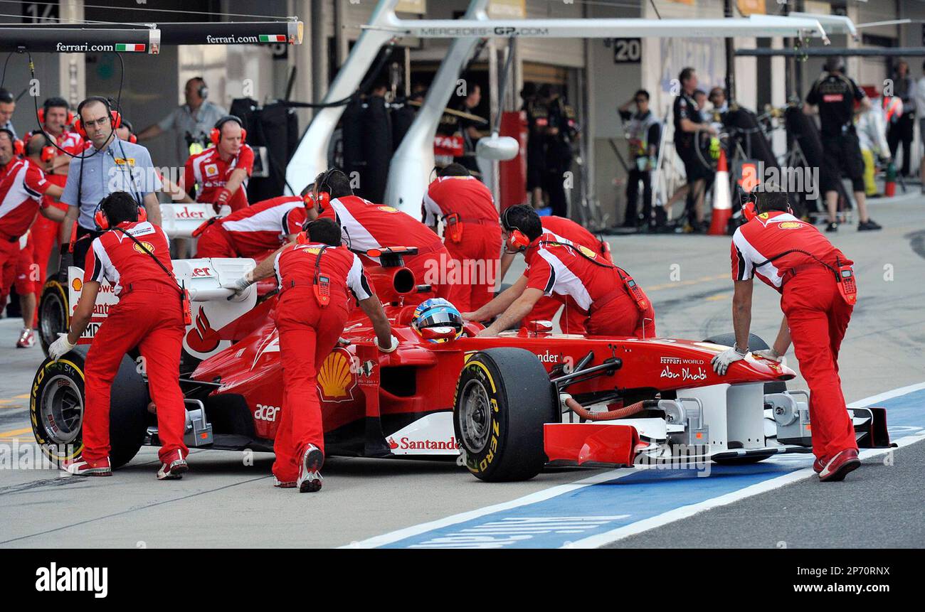 Ferrari mechanics push Spanish driver Fernando Alonso's car back to the ...