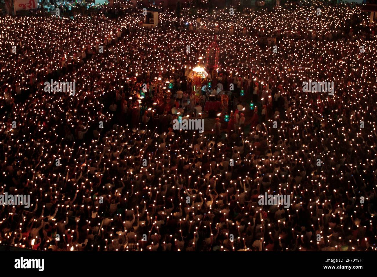 Indian devotees hold earthen lamps as they take part in the Maha Aarti ...