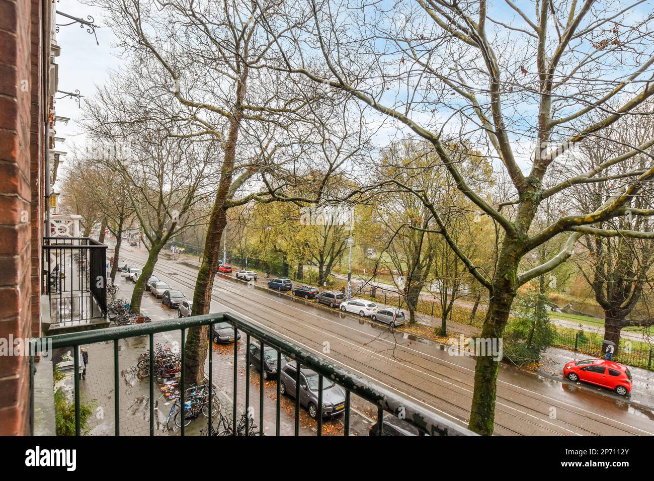 an outside area with trees and cars parked on the side of the street in ...