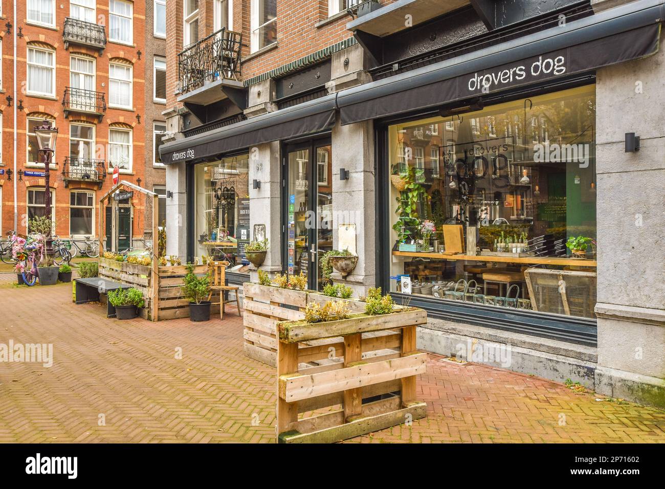 an outside area with tables, benches and plants on the sidewalk in ...