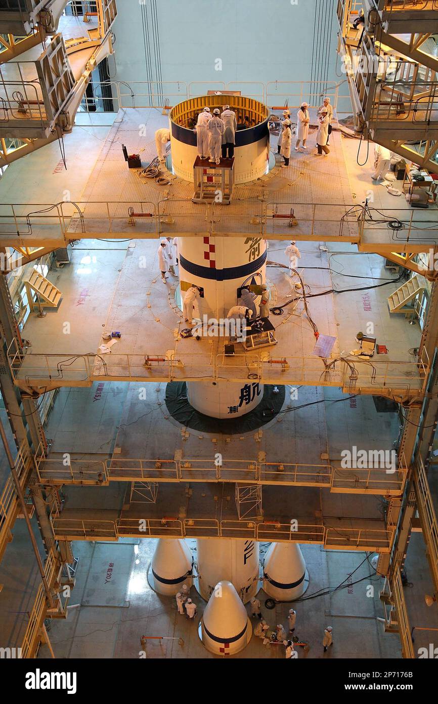 File photo show researchers installing a Long March 2F rocket, which ...
