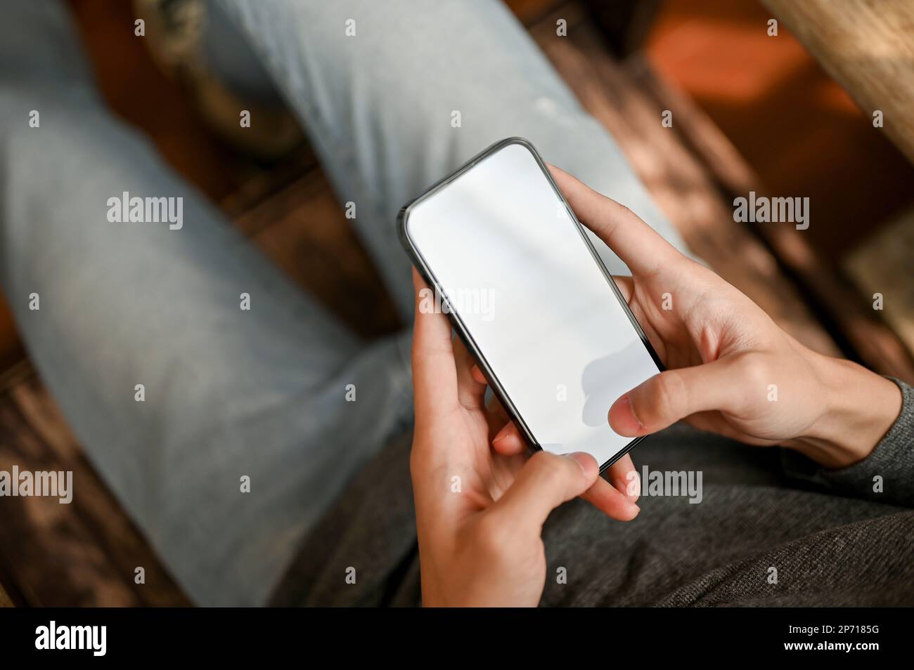 Top view image of an Asian man in casual clothes using his phone. text, chat, message, scrolling ...