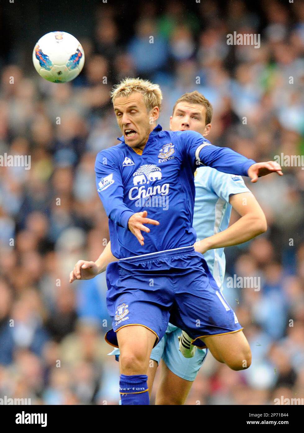 Phil Neville of Everton clears the ball as Edin Dzeko of Manchester ...