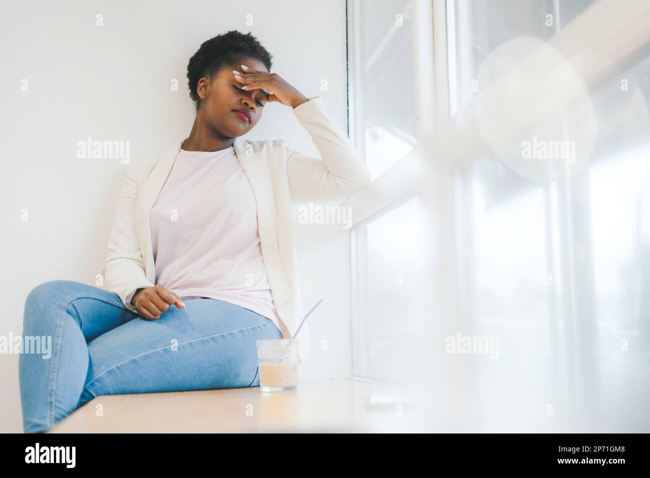 Young African American afro woman with curly hair sitting on cafe ...