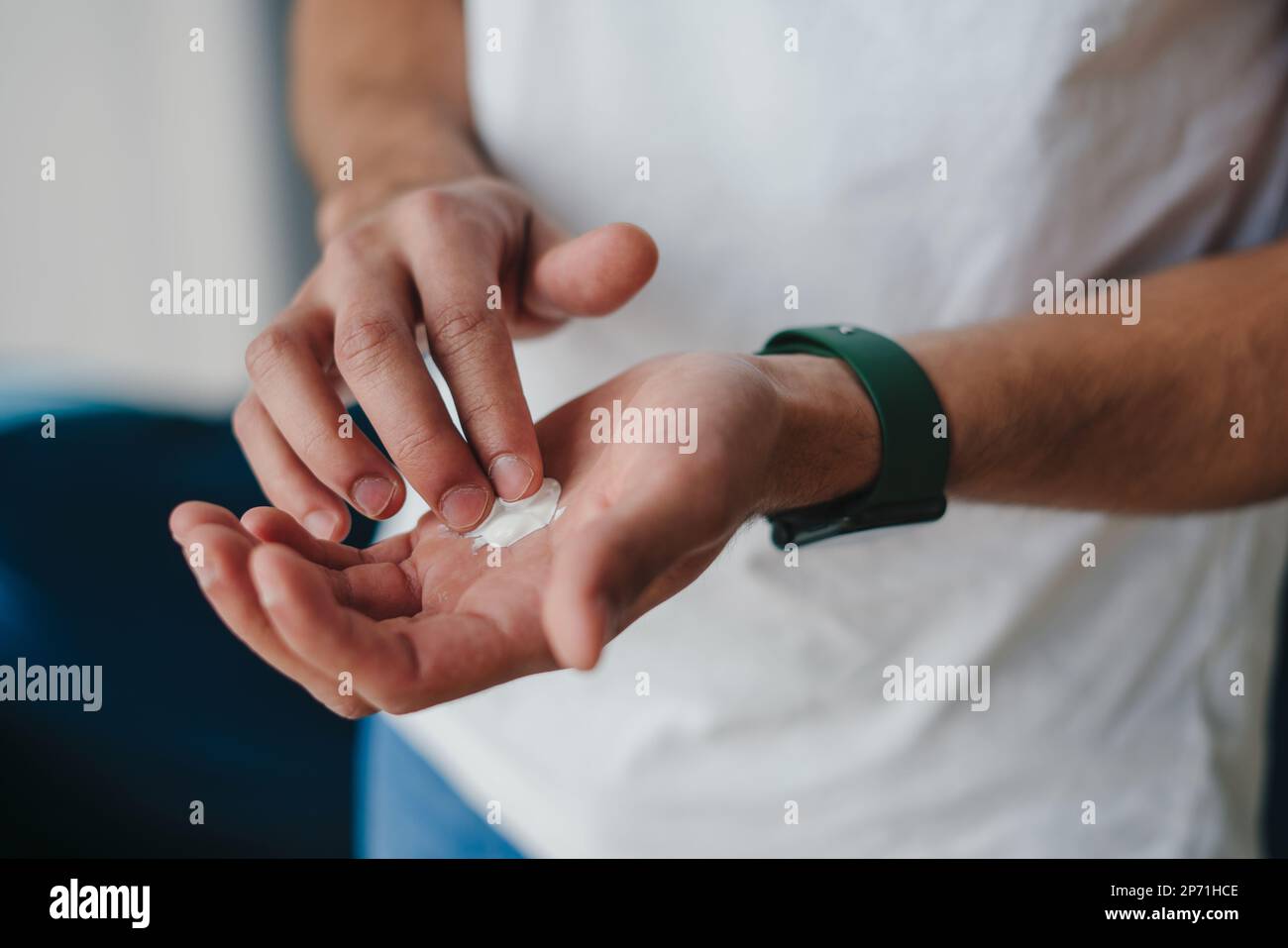 Close-up view of man's hands holding in the palm the cream to apply it ...
