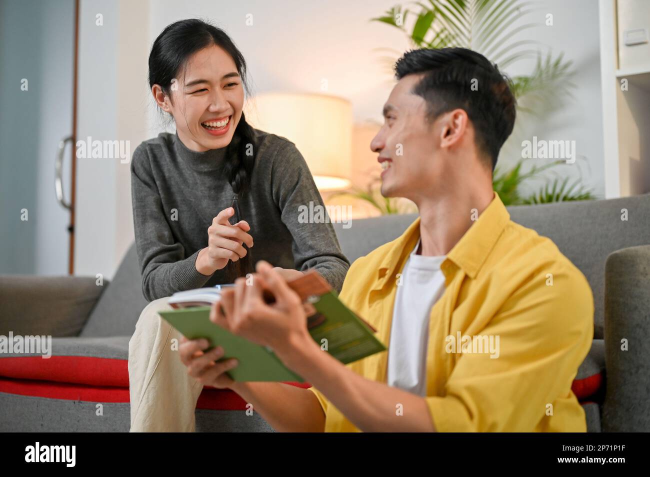 Happy and cheerful young Asian couple are talking and laughing while ...