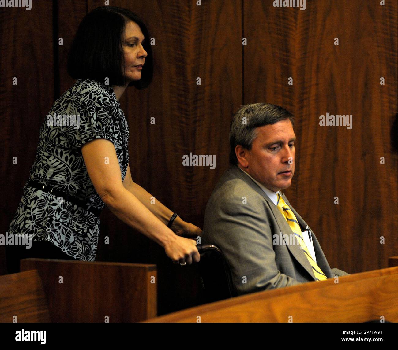 Defendant Michael George, is wheeled into the courtroom by his wife ...