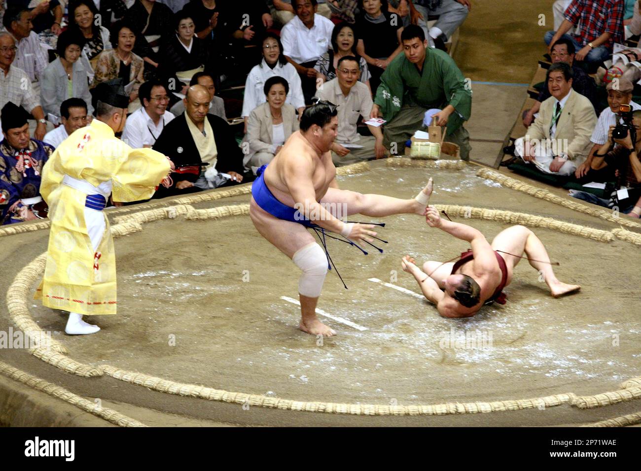 Czech maegashira No. 15 Takanoyama (R) is pulled down from back by Mongolian maegashira No. 12 ...